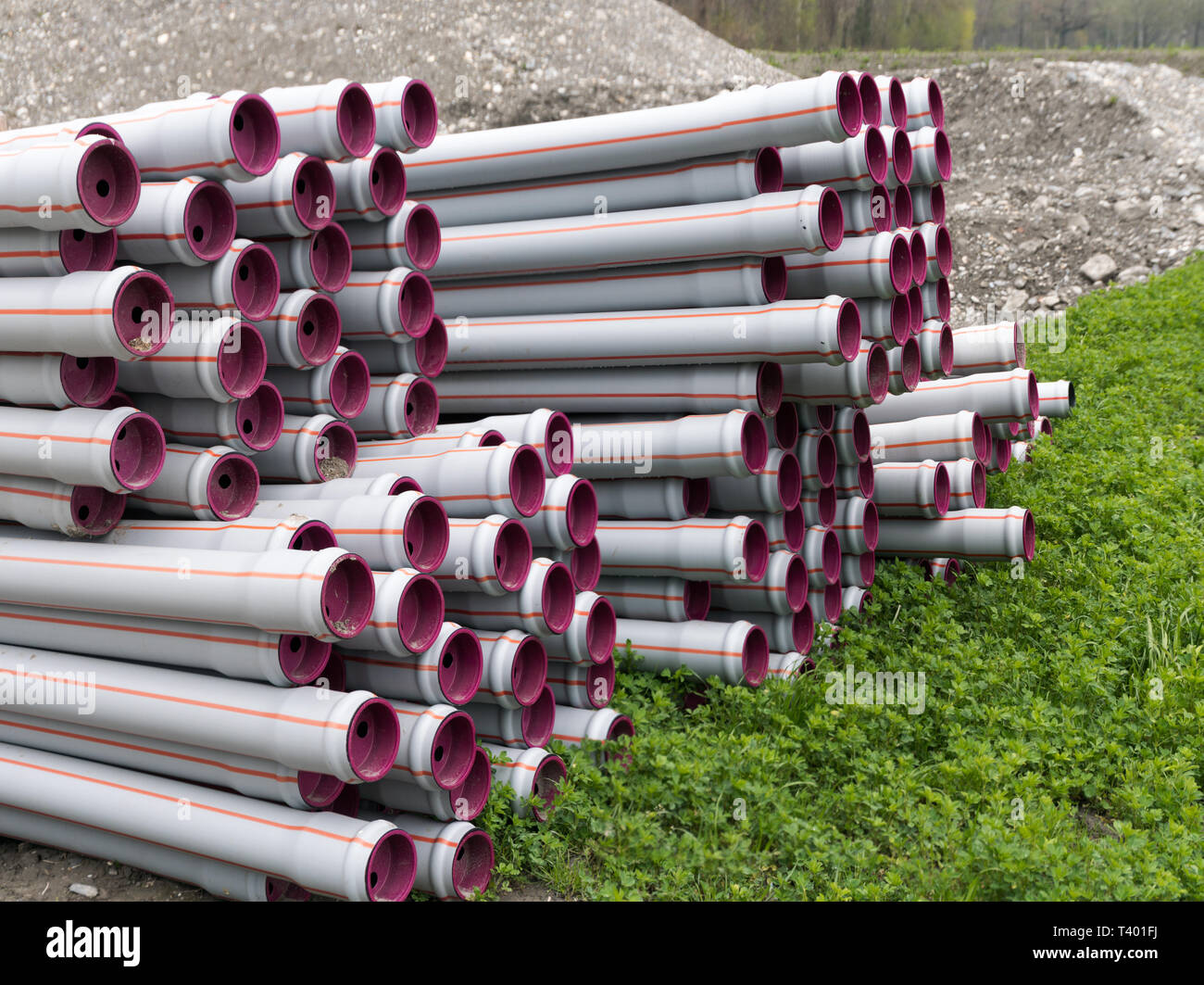 many stacked long plastic pipe tubes ready for building a water supply ...