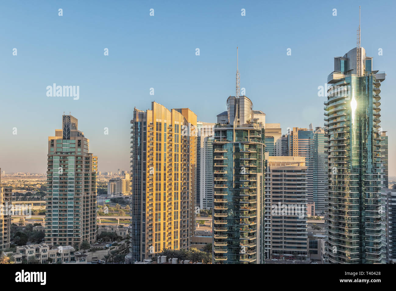 View of skyscrapers with blue sky and sun reflecting on window. With ...