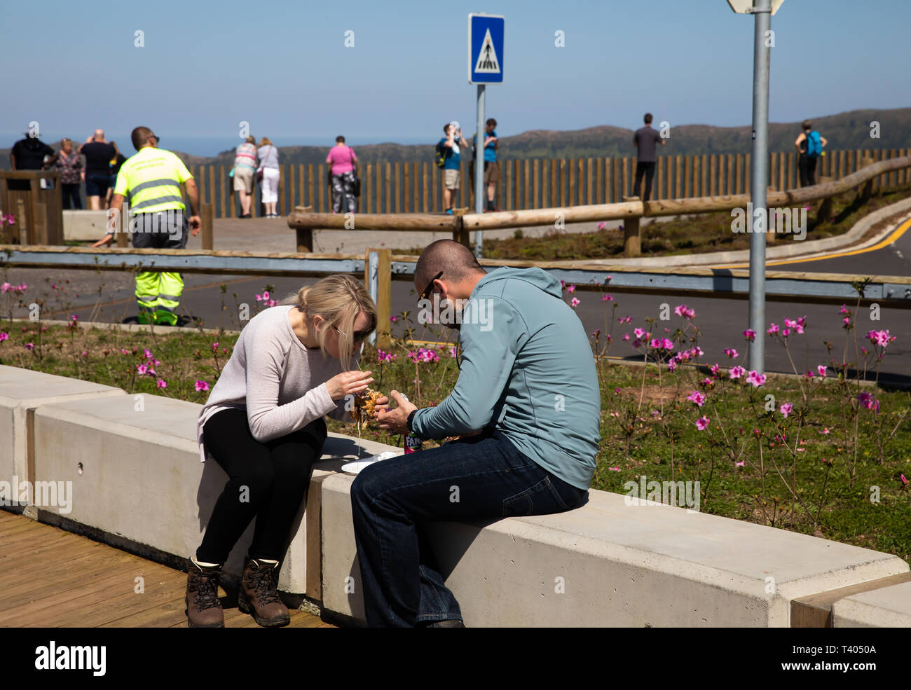 People sitting eating on a wall on a viewpoint in The Azores Stock ...