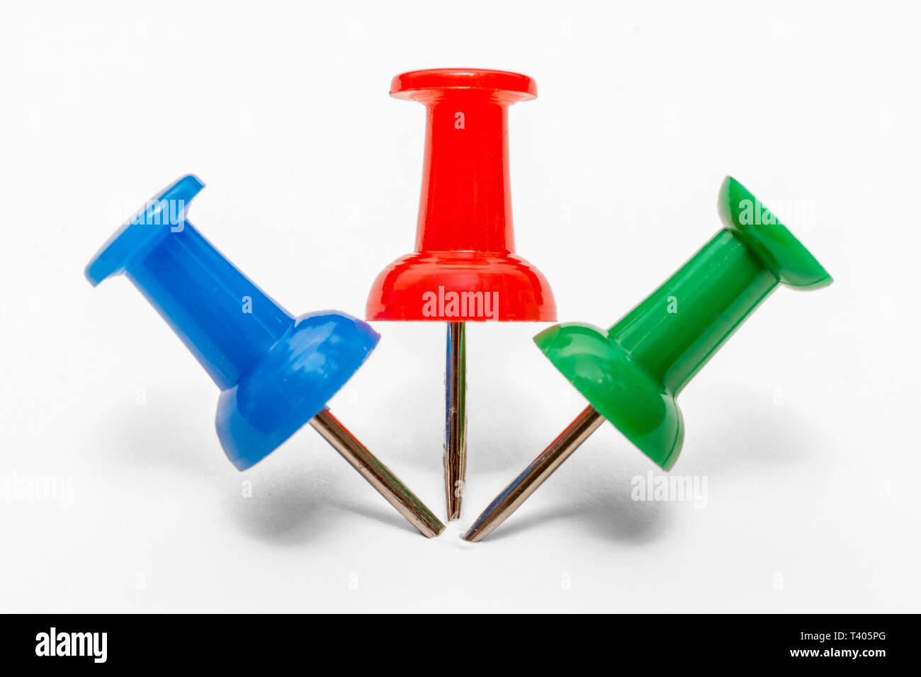 Blue, red and green pin are stuck side by side in the paper Stock Photo ...