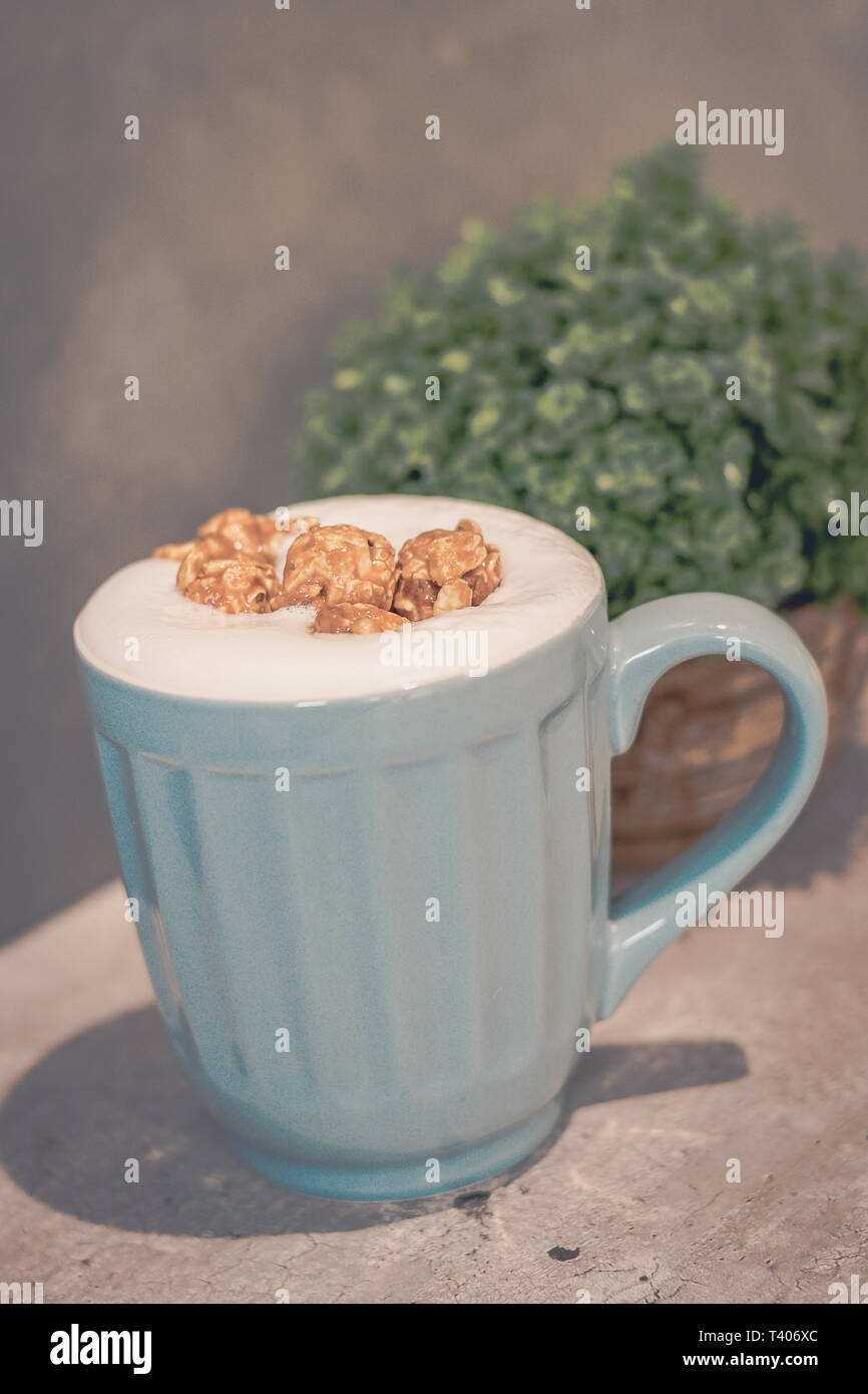 Caramel Popcorn Latte (no caffeine) in light blue mug and potted plant ...
