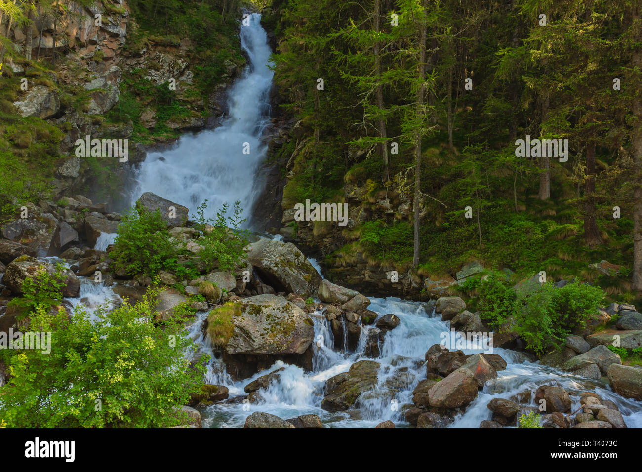 a deafening waterfall falling from glaciers in the National Park of ...