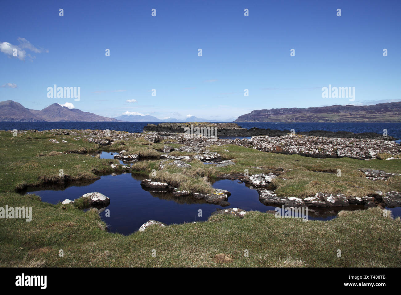 Grassy pools on the Isle of Muck with the Isles of Eigg Rhum and Skye ...