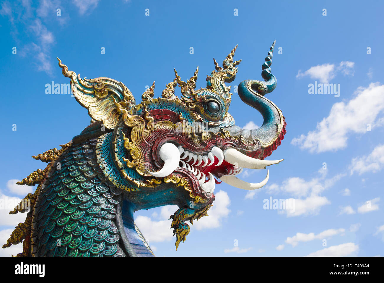 The head of a dragon against a blue sky. Buddhist temple Wat Rong Seur ...