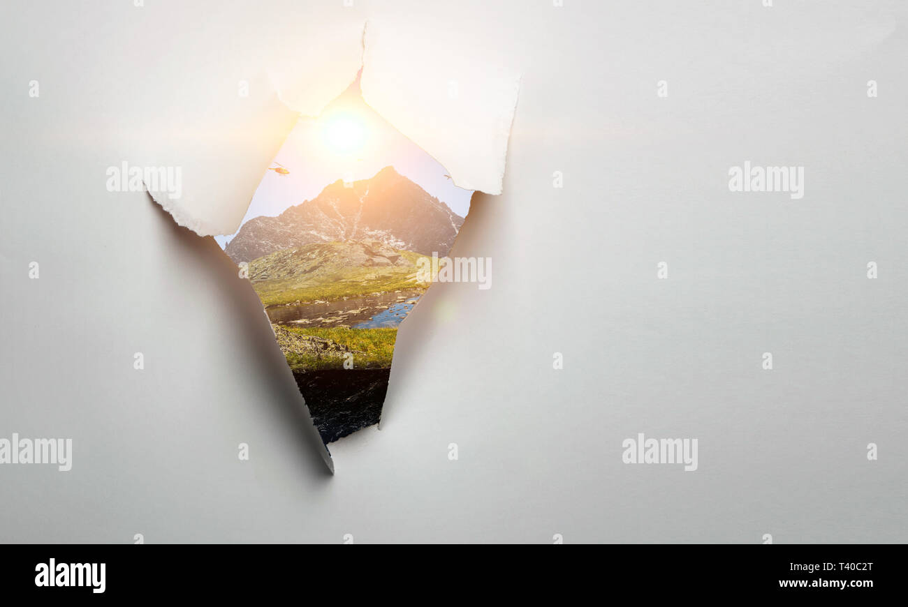 Paper torn hole effect on the wall. Mixed media Stock Photo - Alamy