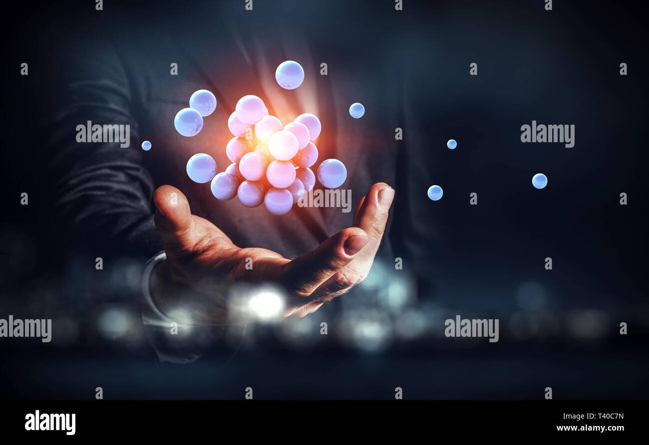 Businessman hand holding a bunch of spheres levitating above. Mixed ...