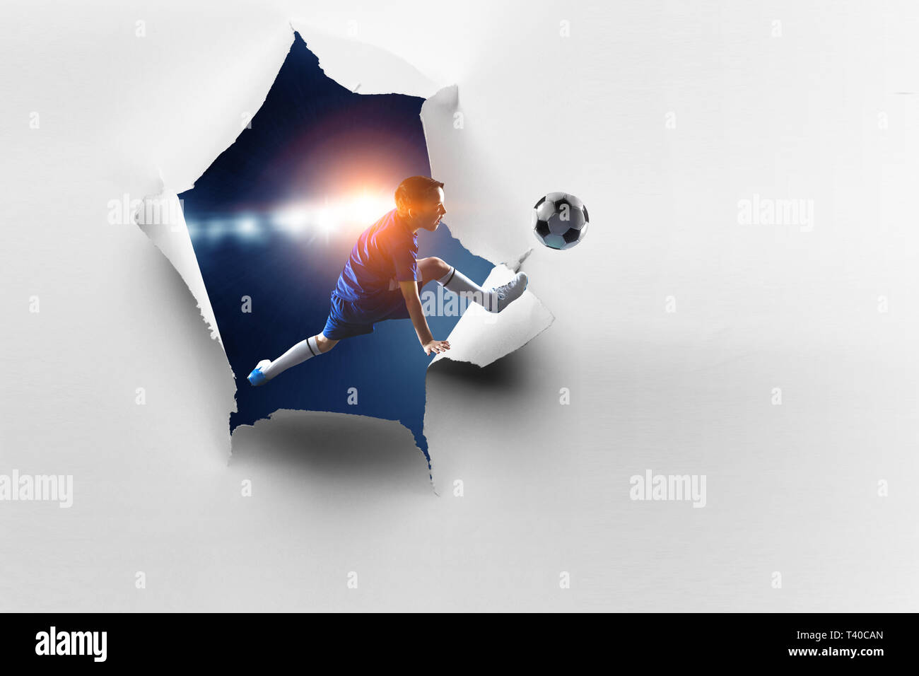 Paper torn hole effect and a kid playing soccer. Mixed media Stock ...