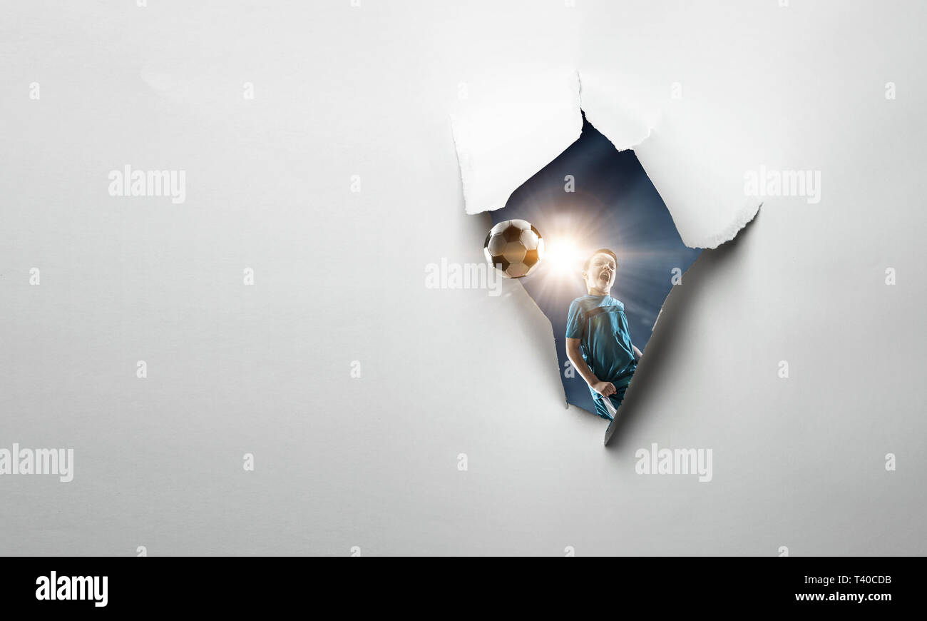 Paper torn hole effect and a kid playing soccer. Mixed media Stock ...