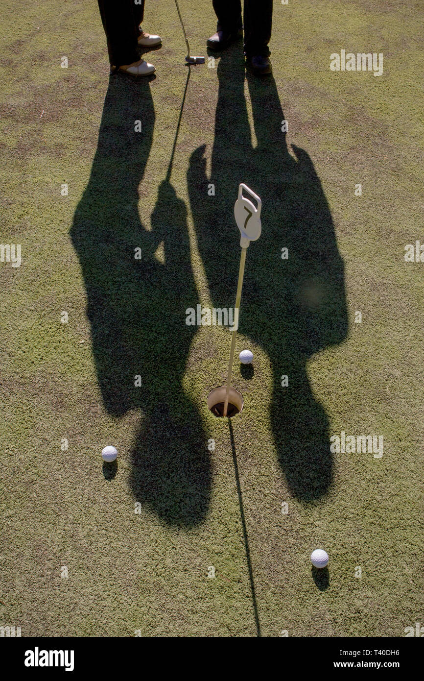 the shadow of 2 golfers on a putting green Stock Photo - Alamy