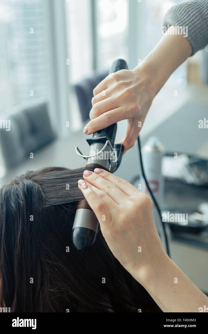 Hairdresser straightening models hair in a beauty salon Stock Photo - Alamy