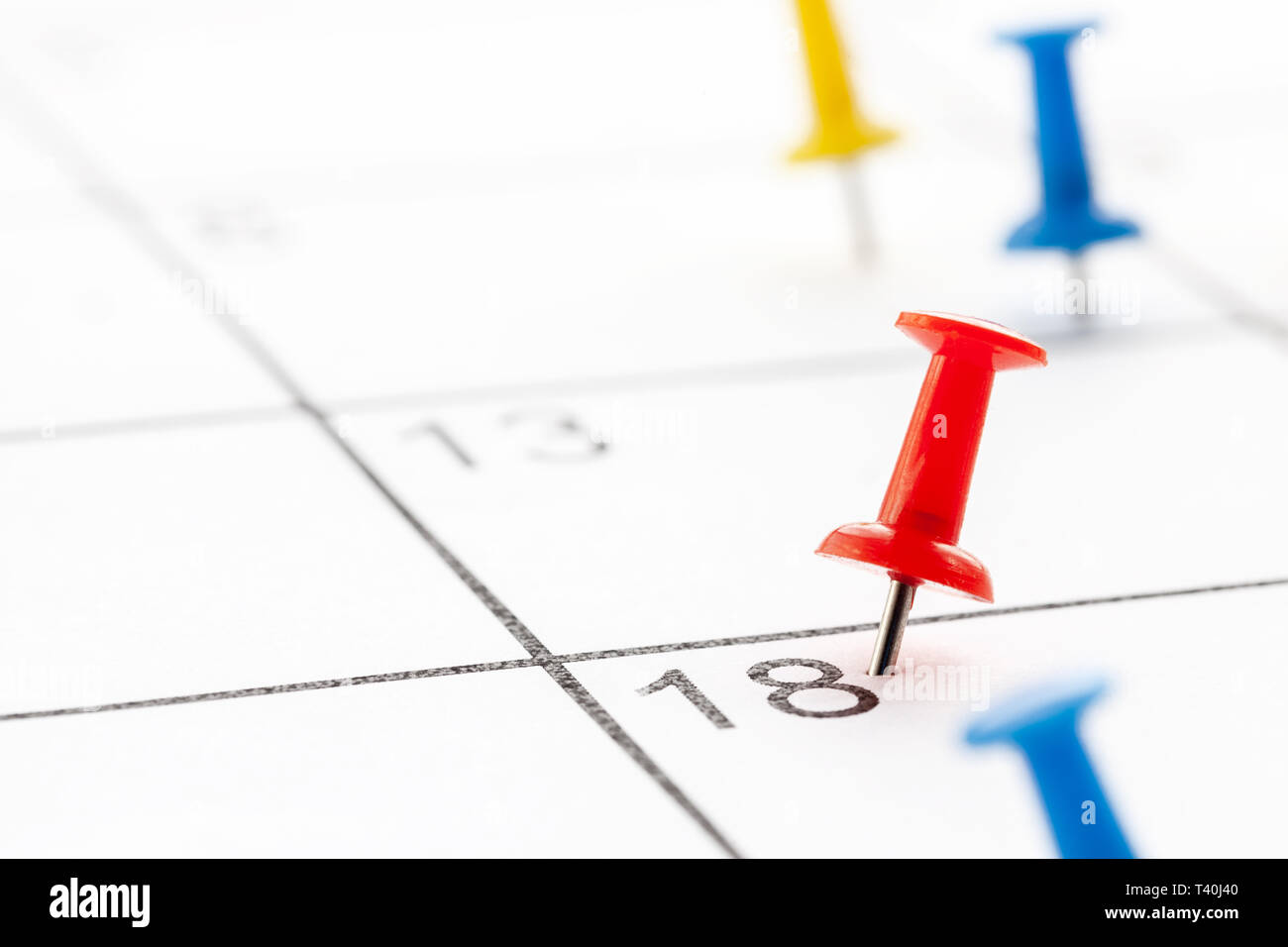 Colored push pin on white calendar background. Copy space for text ...