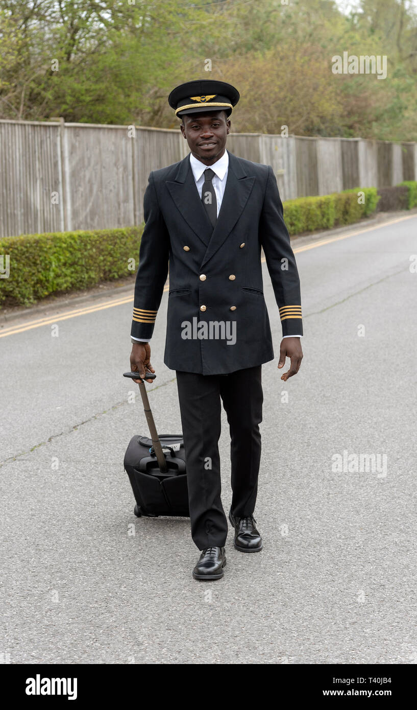 Airline pilot in uniform walking to work pulling a flight bag Stock ...