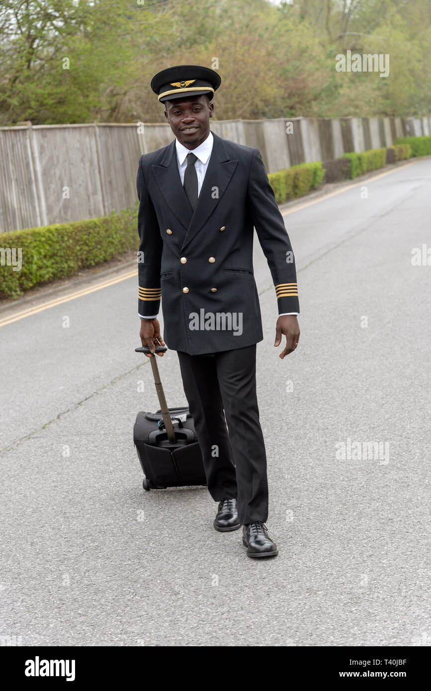 Airline pilot in uniform walking to work pulling a flight bag Stock ...