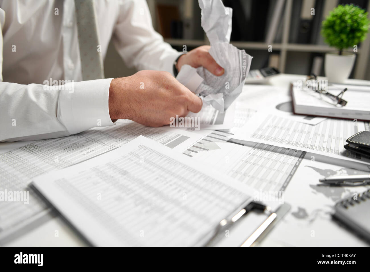 Angry businessman has stress and troubles with bad reports, he breaks ...