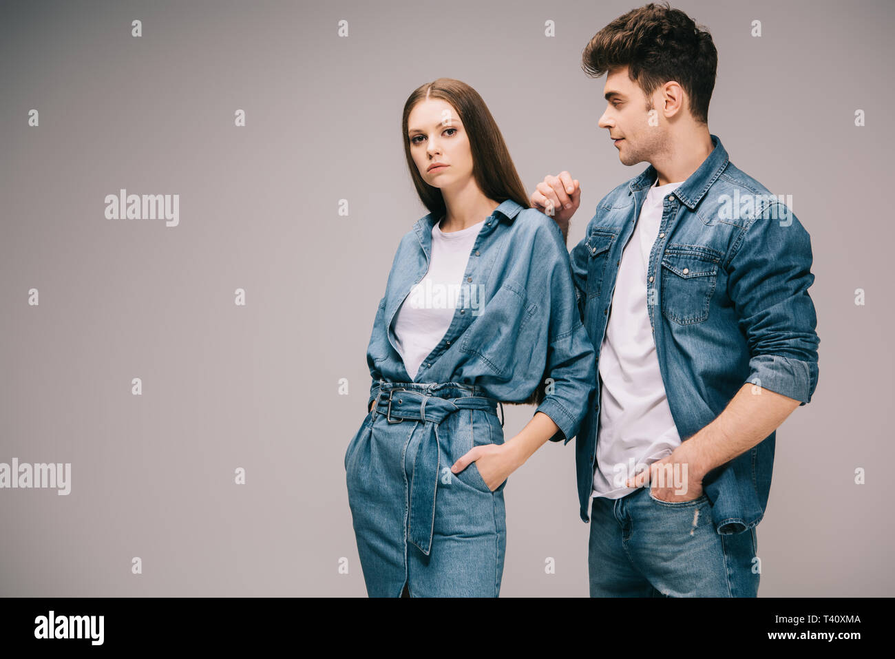 girlfriend in denim dress and boyfriend in jeans and shirt on grey ...