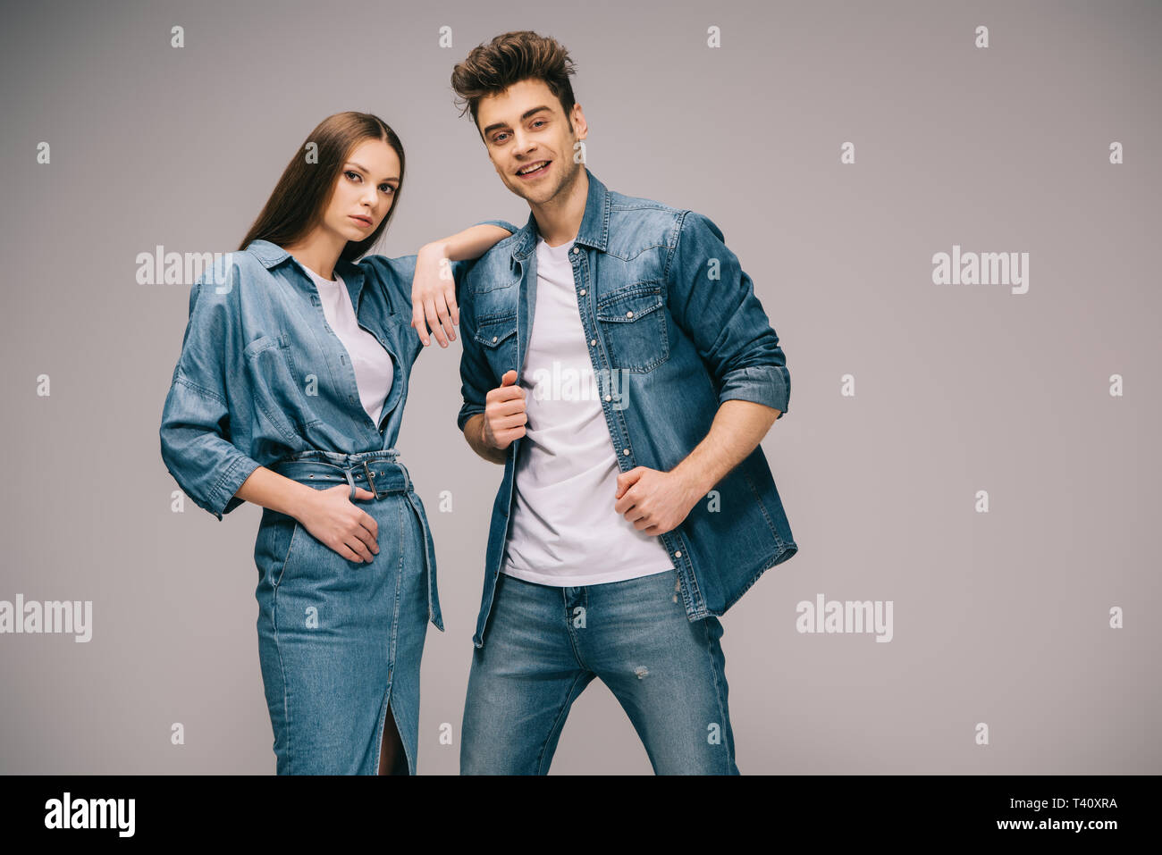 girlfriend in denim dress and smiling boyfriend in jeans and shirt ...