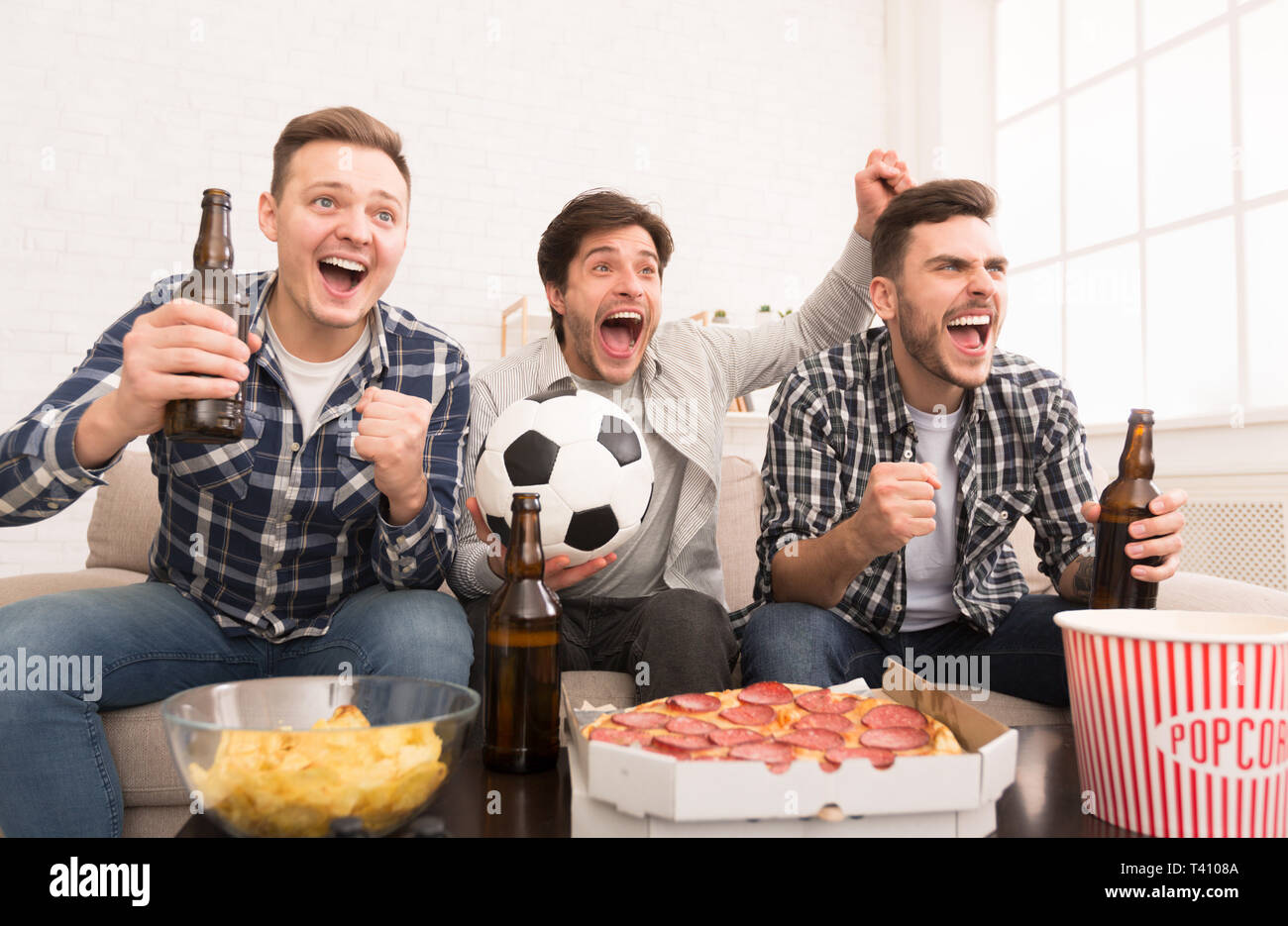 Goal. Happy men watching football match at home Stock Photo - Alamy