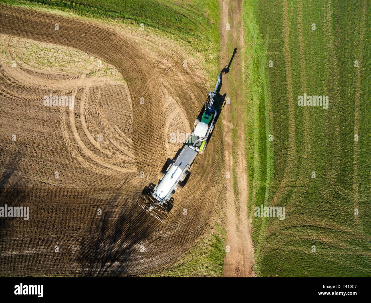 aerial view of a tractor with a modern ground fertilizer trailer on ...