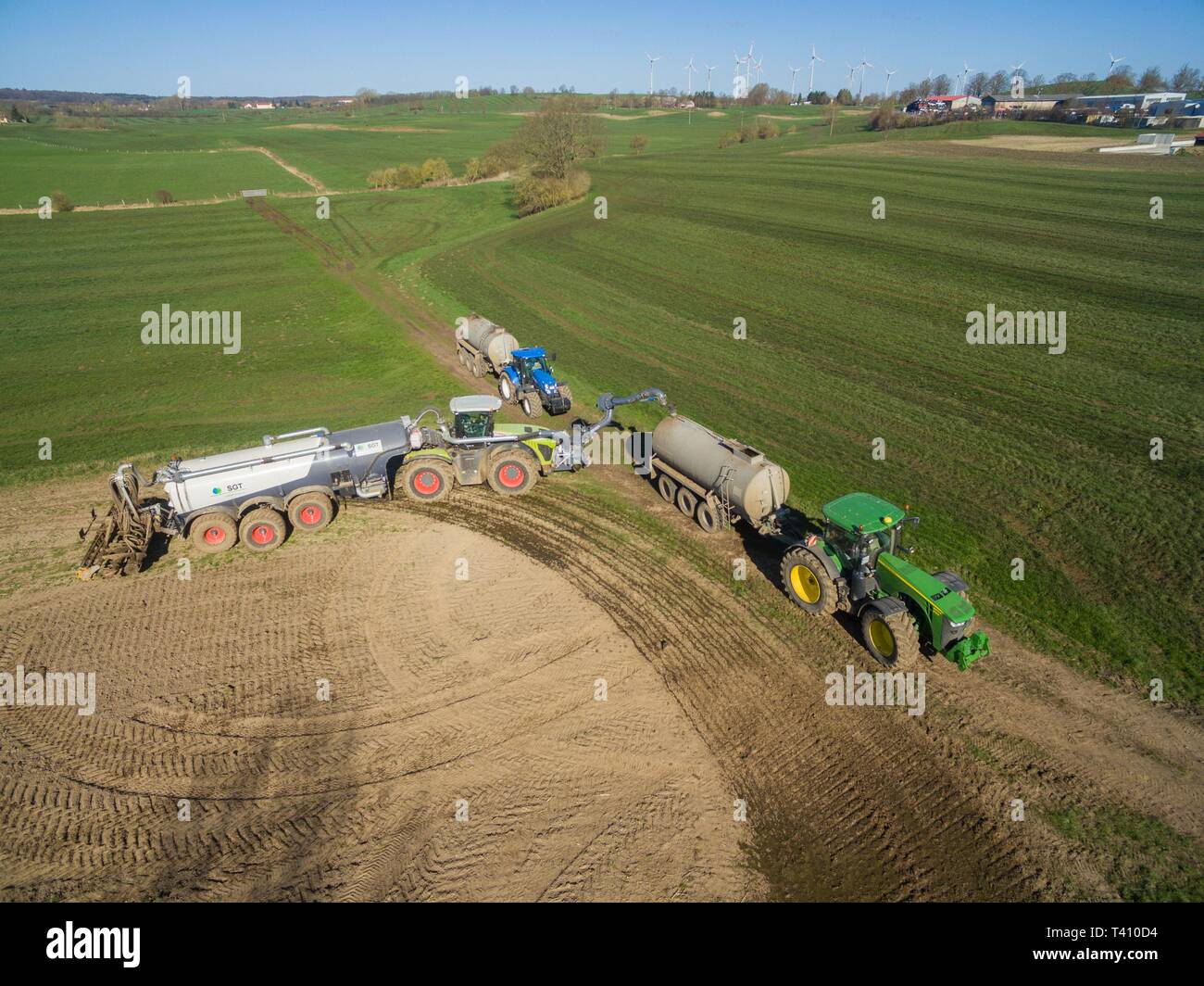 aerial view of a tractor with a modern fertilizer trailer and a second ...