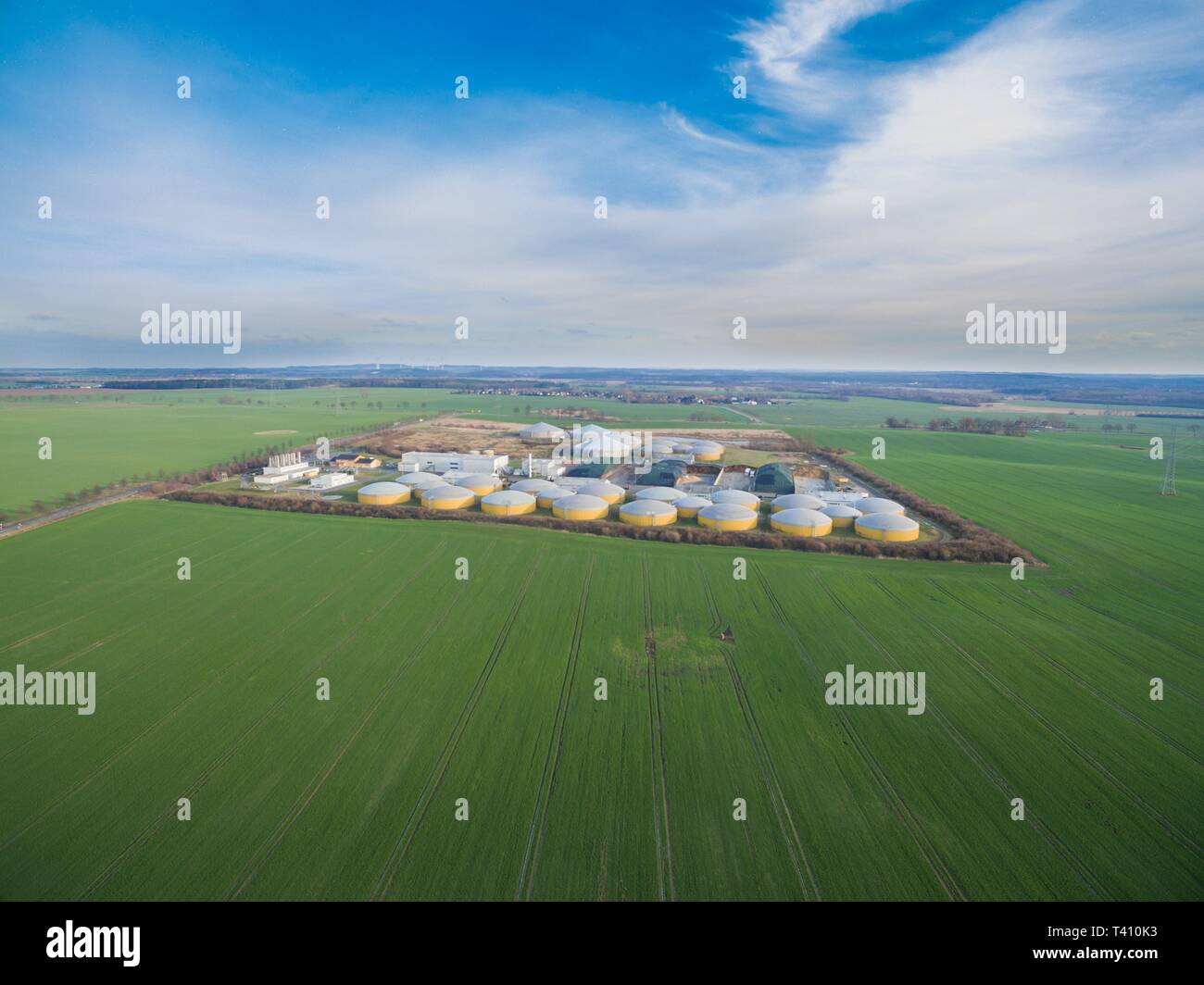 Aerial view of a big biogas plant between green agricultural fields in ...