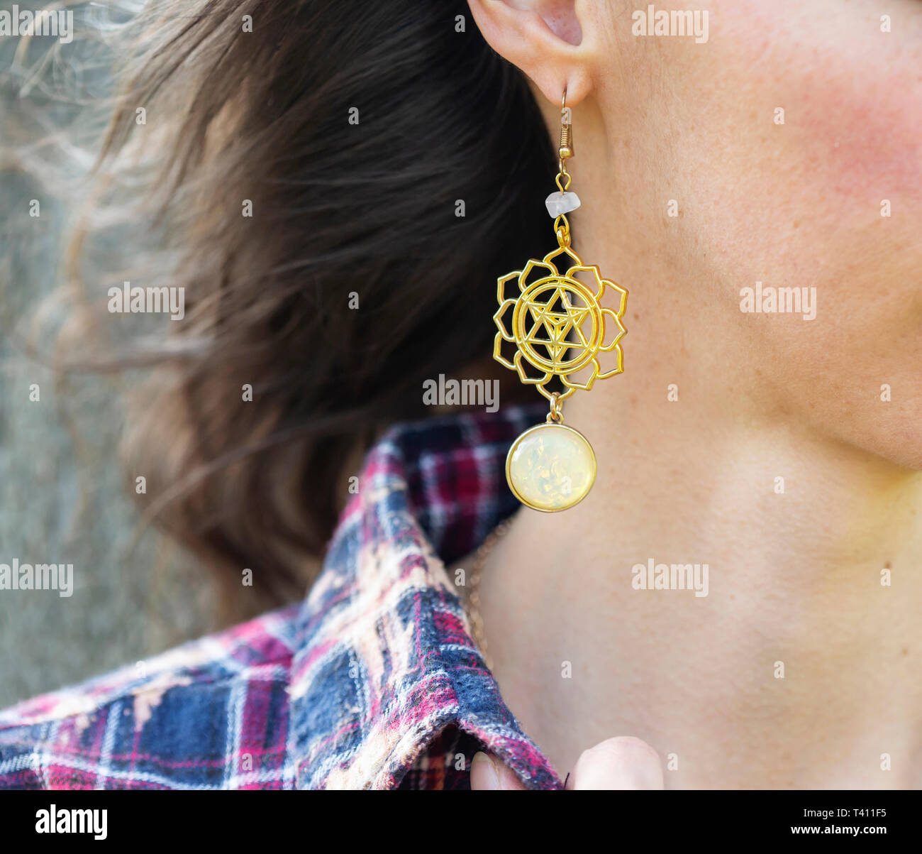 Merkabah Metatron symbol metal earrings on female ear Stock Photo - Alamy