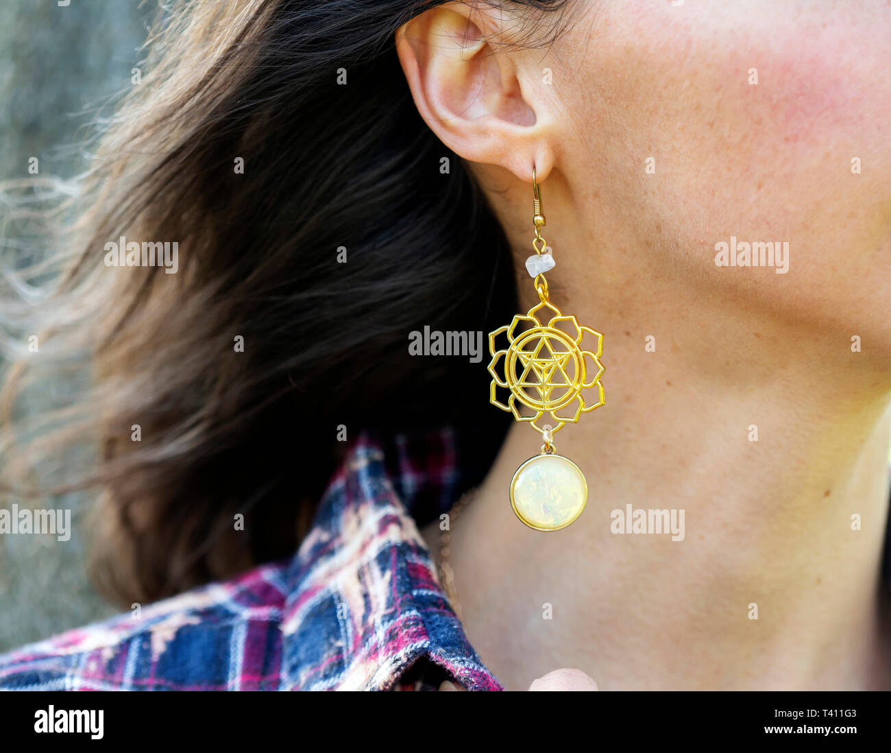 Merkabah Metatron symbol metal earrings on female ear Stock Photo - Alamy
