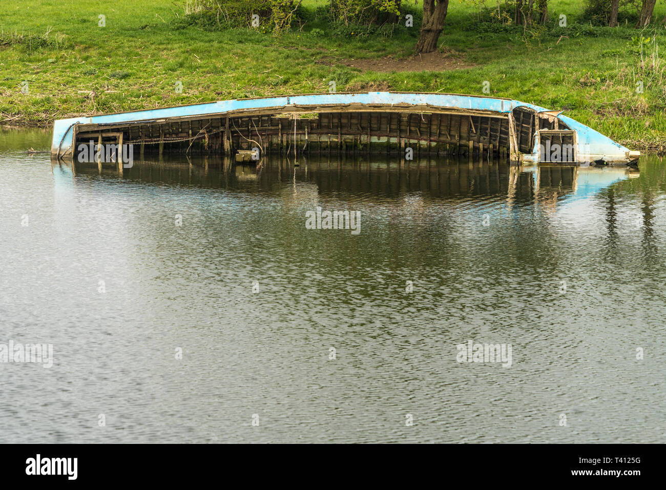 Half submerged boat wreck on the banks of a river Stock Photo - Alamy