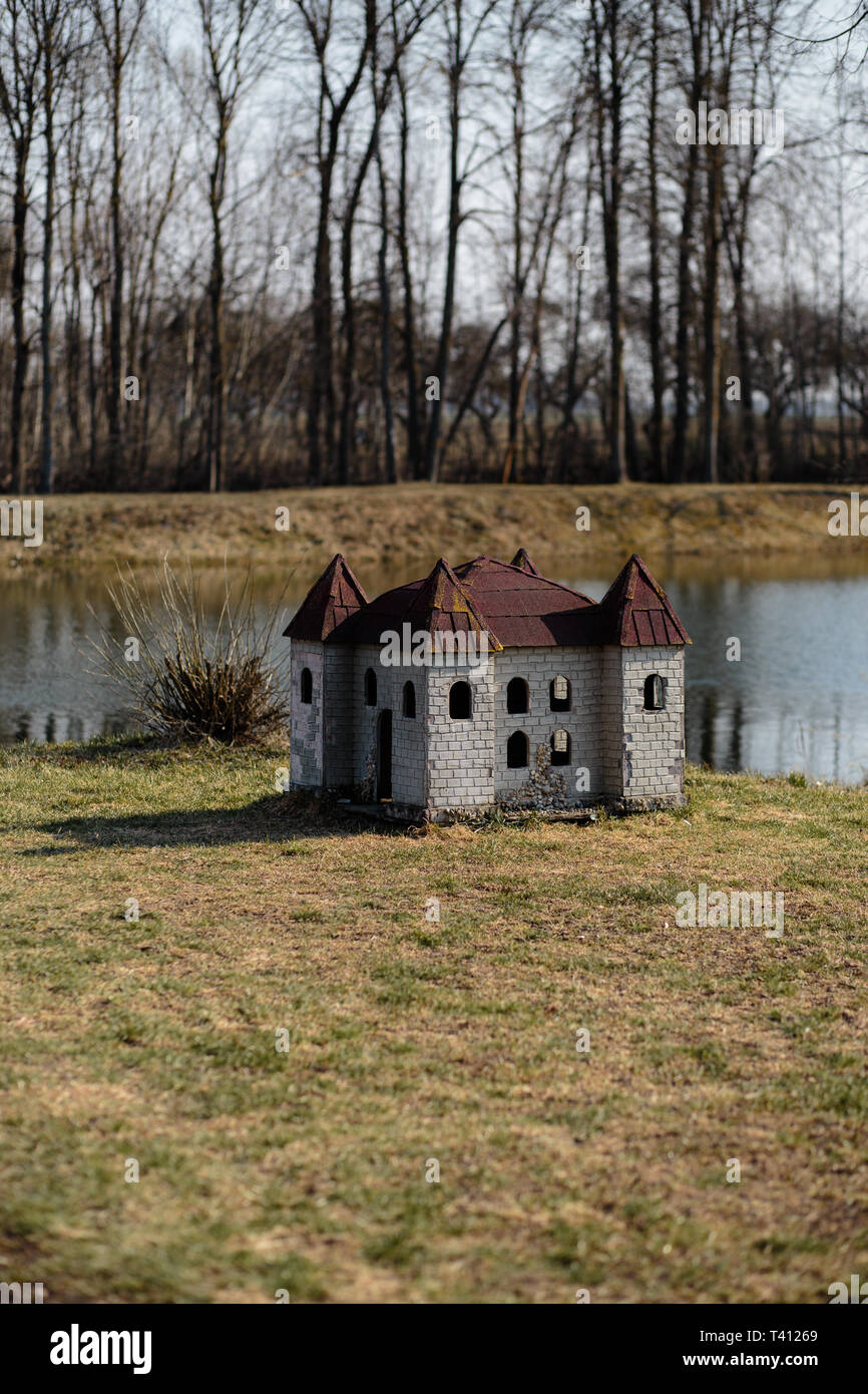 Doghouse in shape of a castle on the river bank in a park Stock Photo ...
