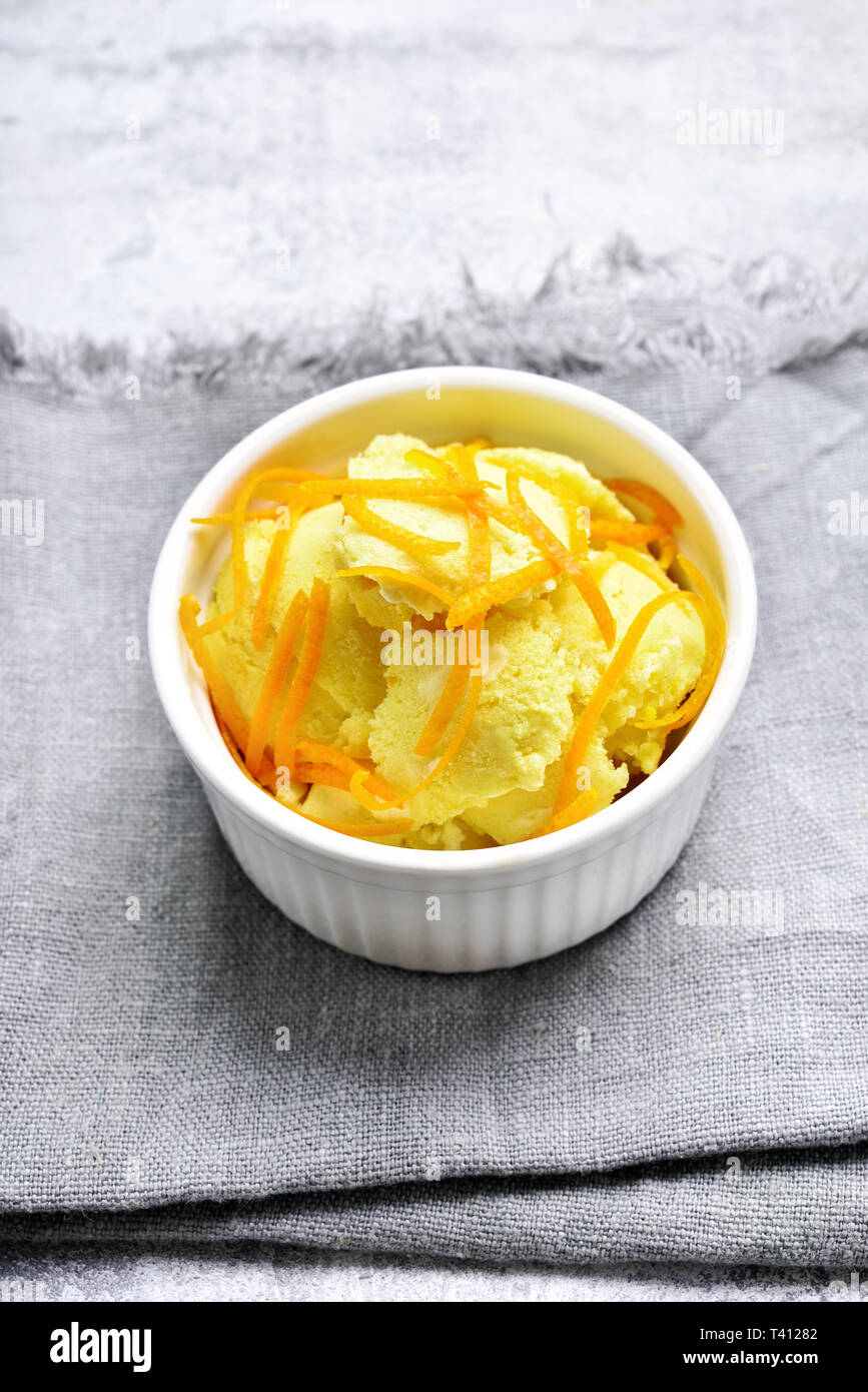 Orange vanilla ice cream in bowl on stone background. Cold summer ...