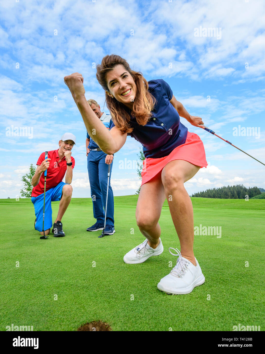 Female golf player is enthusiastic about a successful putt on the green ...