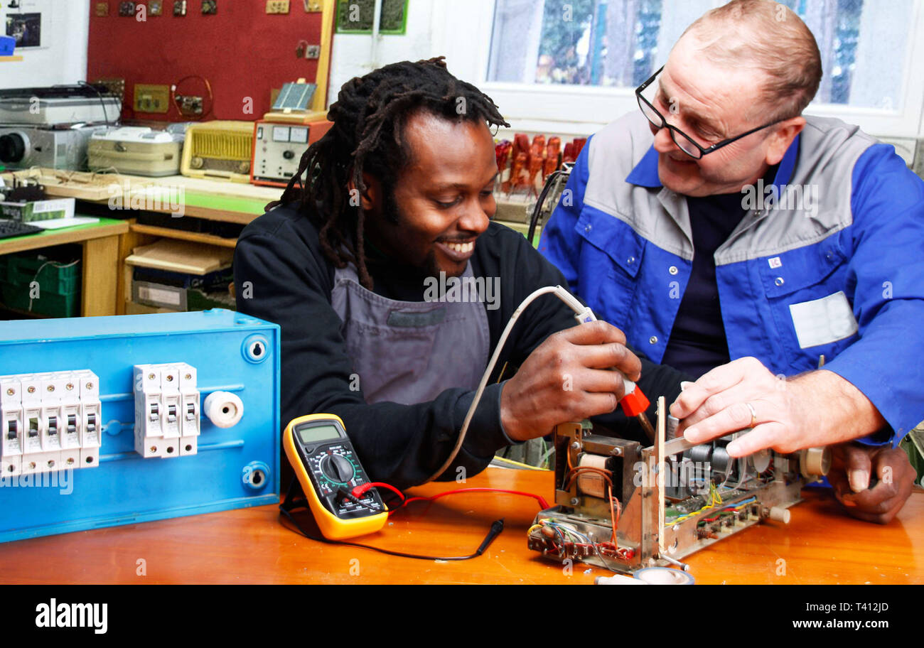 Teamwork, Two Electricians working together Stock Photo - Alamy