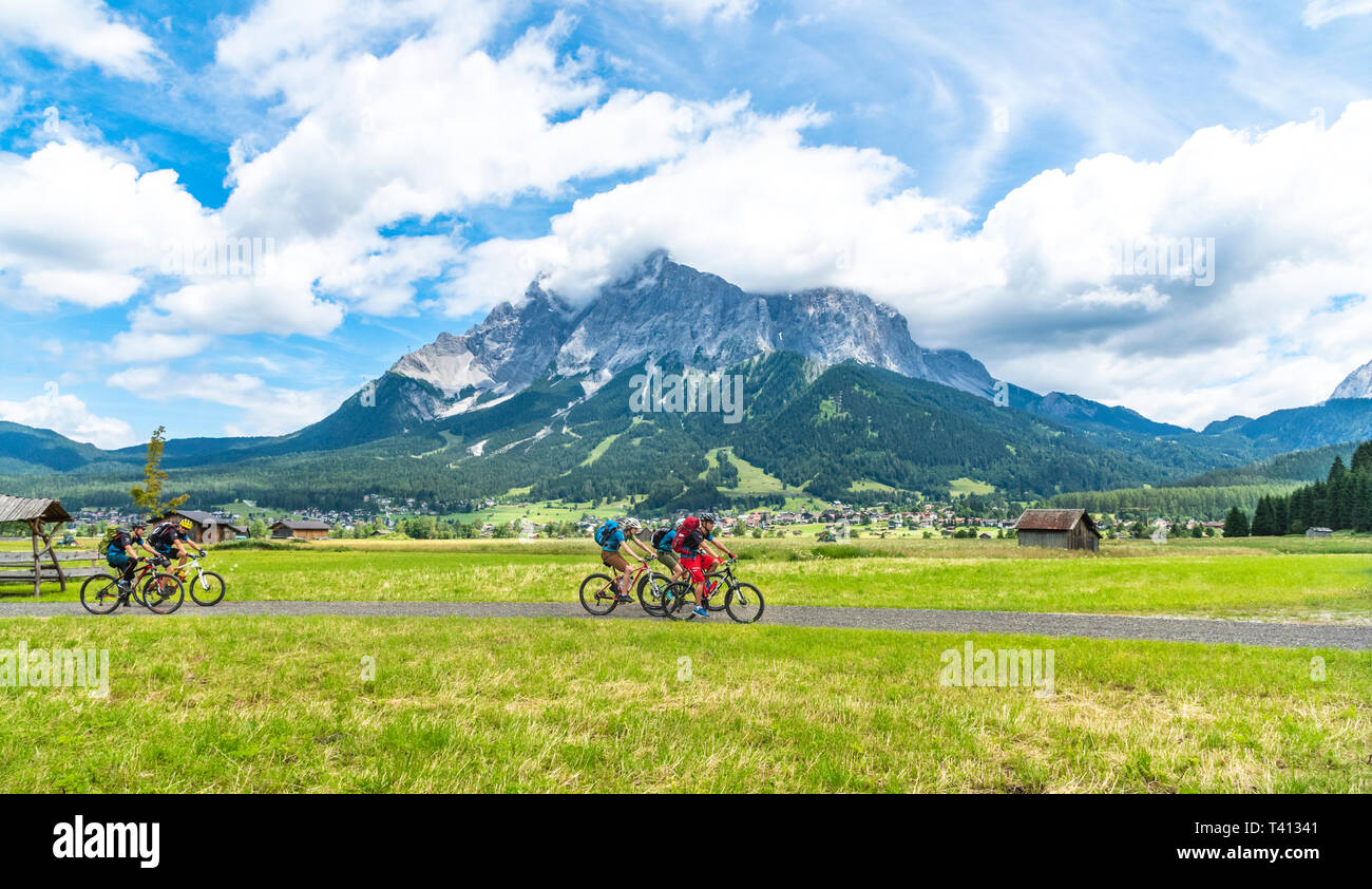 Group of cyclists passing the Ehrwalder Moos with Zugspitze in ...