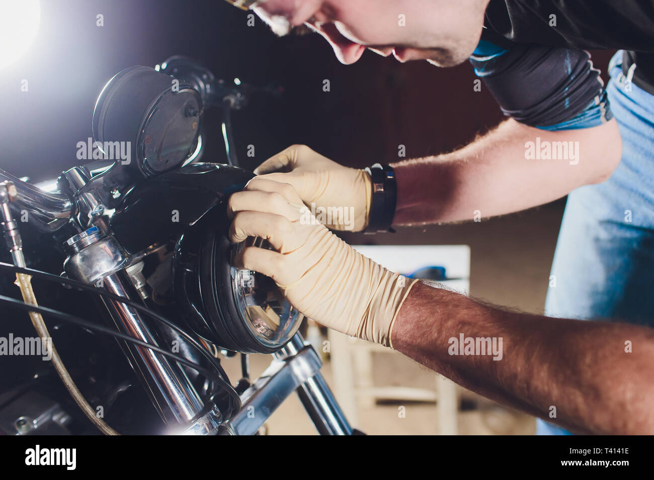 Man fixing bike. Confident young man repairing motorcycle near his ...