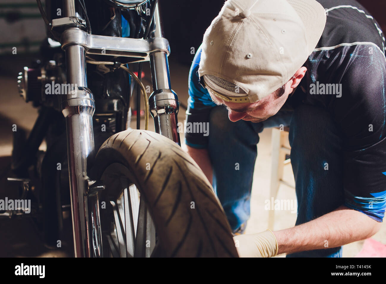 Man fixing bike. Confident young man repairing motorcycle near his ...