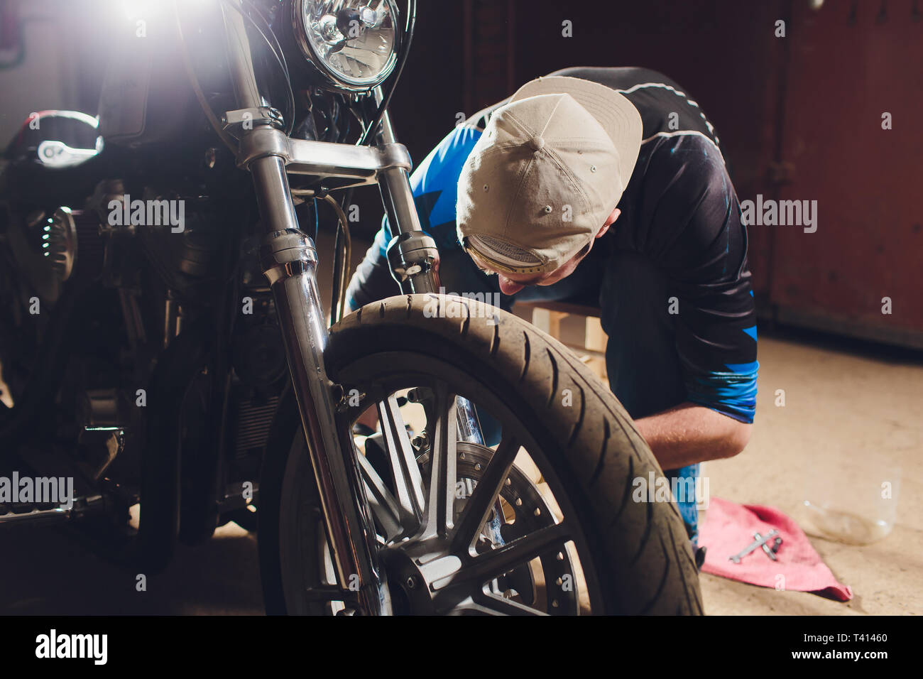 Man fixing bike. Confident young man repairing motorcycle near his ...