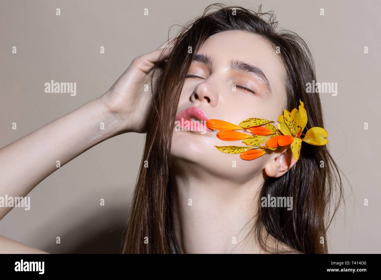 Model closing her eyes while posing with flower in hair Stock Photo - Alamy