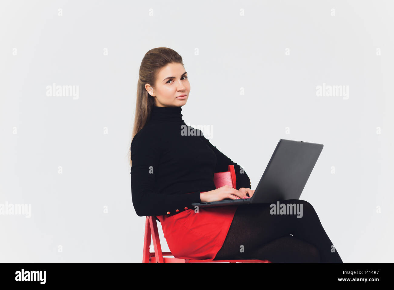 Photo of beautiful woman 20s smiling and using computer with legs ...