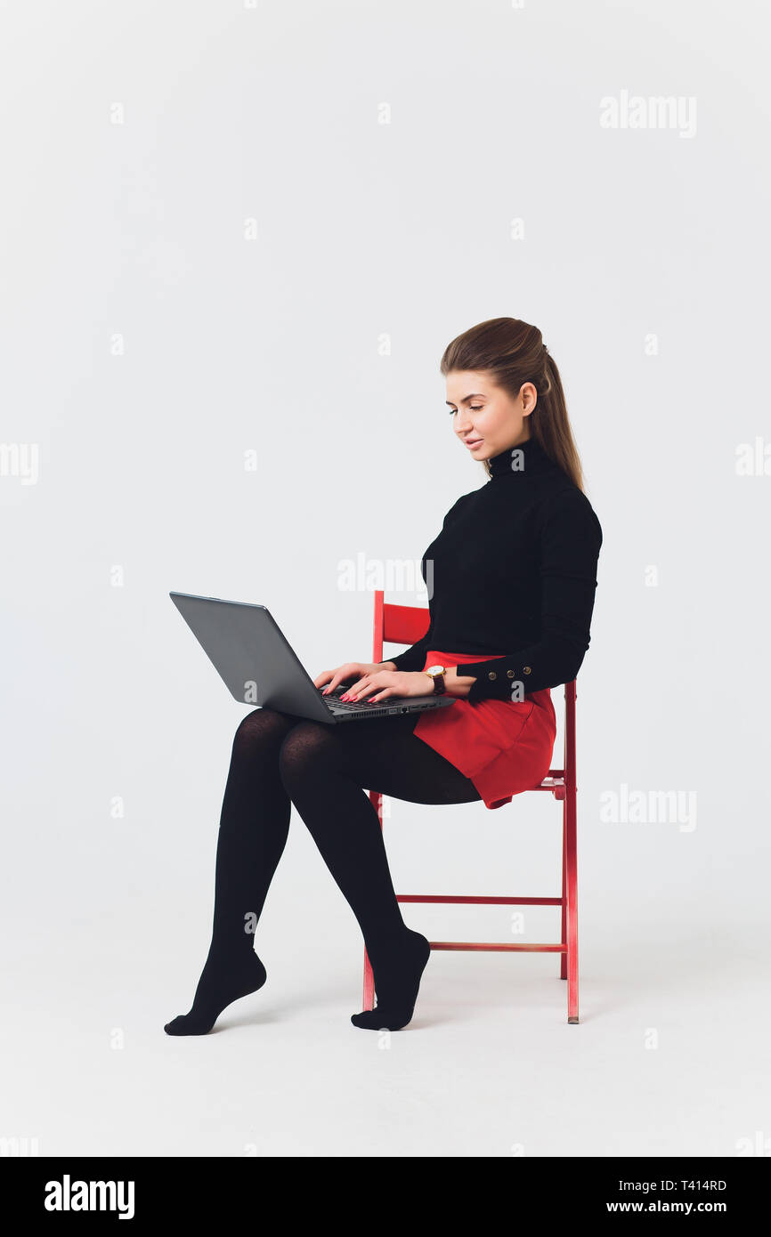 Photo of beautiful woman 20s smiling and using computer with legs ...