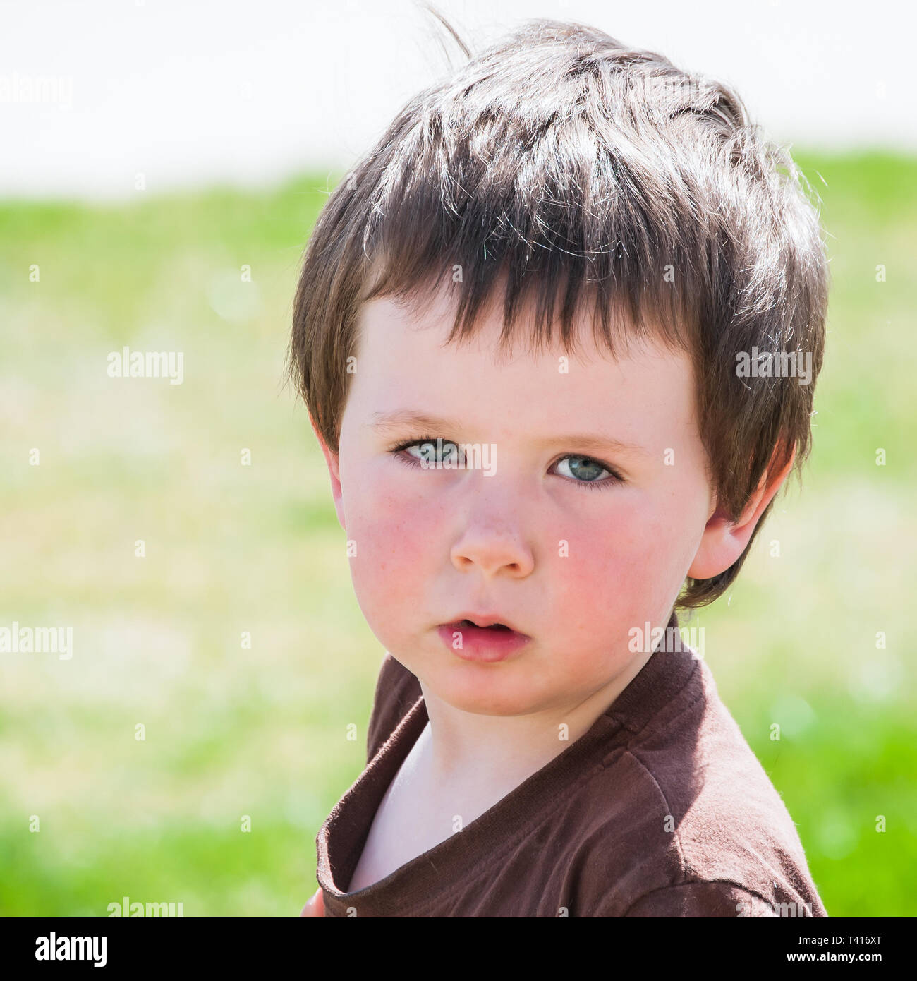 Cute little boy looking over his shoulder with attitude Stock Photo - Alamy