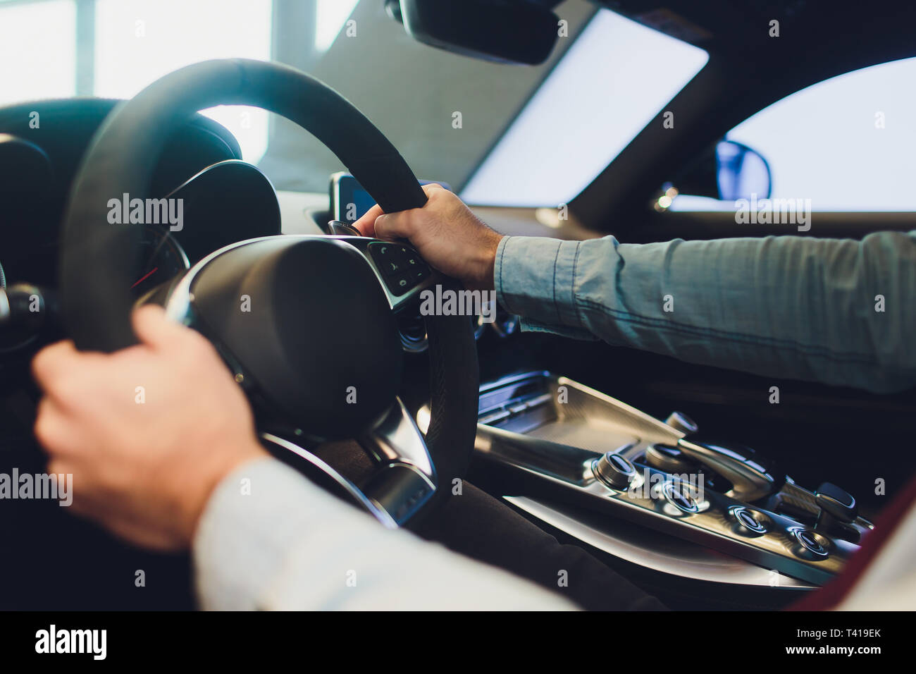 Businessman driving luxury modern car in the city. Close up man's hand ...