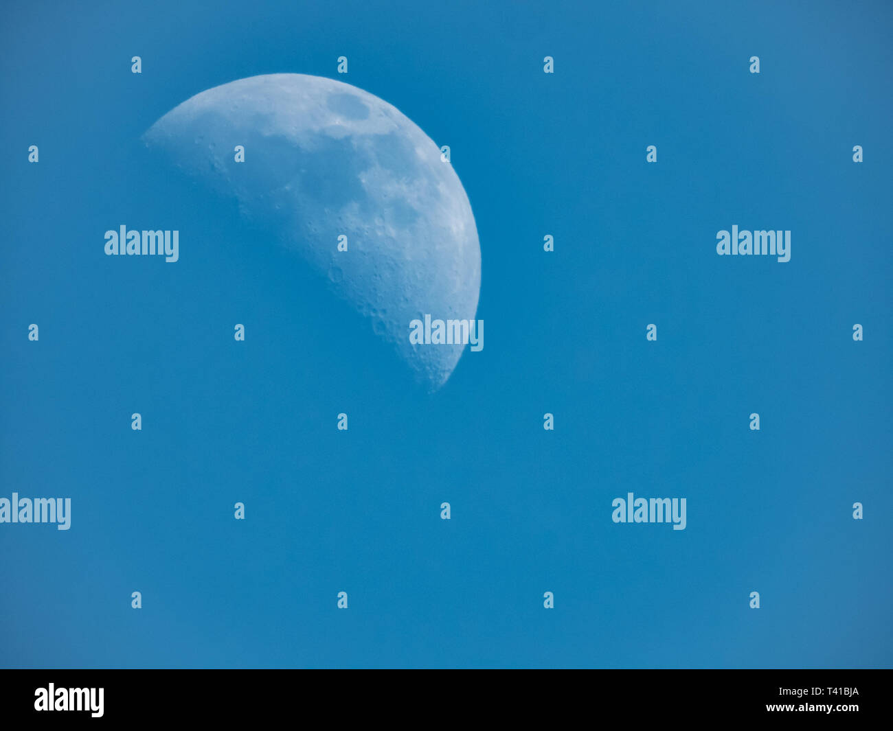 a crescent moon with clear visibility reveals many craters on the ...