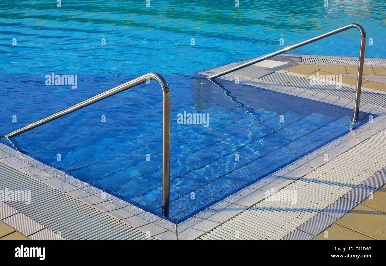 Swimming pool with ladder and steel handrail in the spa Stock Photo - Alamy
