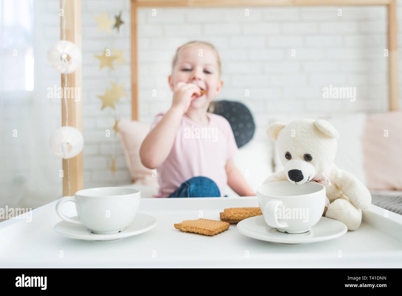 Cute little girl drinks tea with her teddy bear Stock Photo - Alamy
