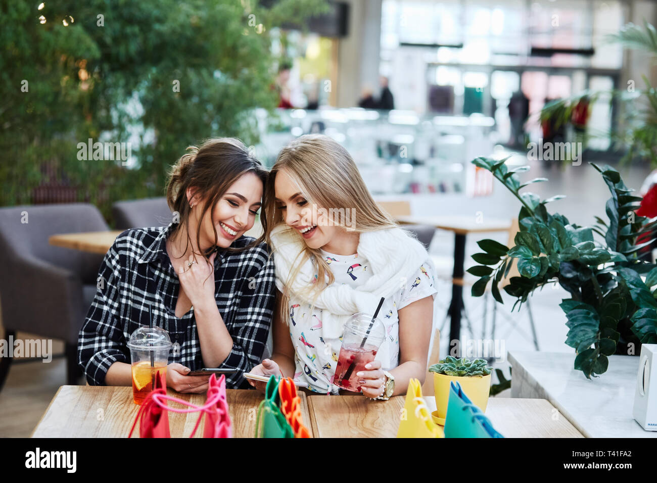 Pretty girls posing while shopping Stock Photo - Alamy