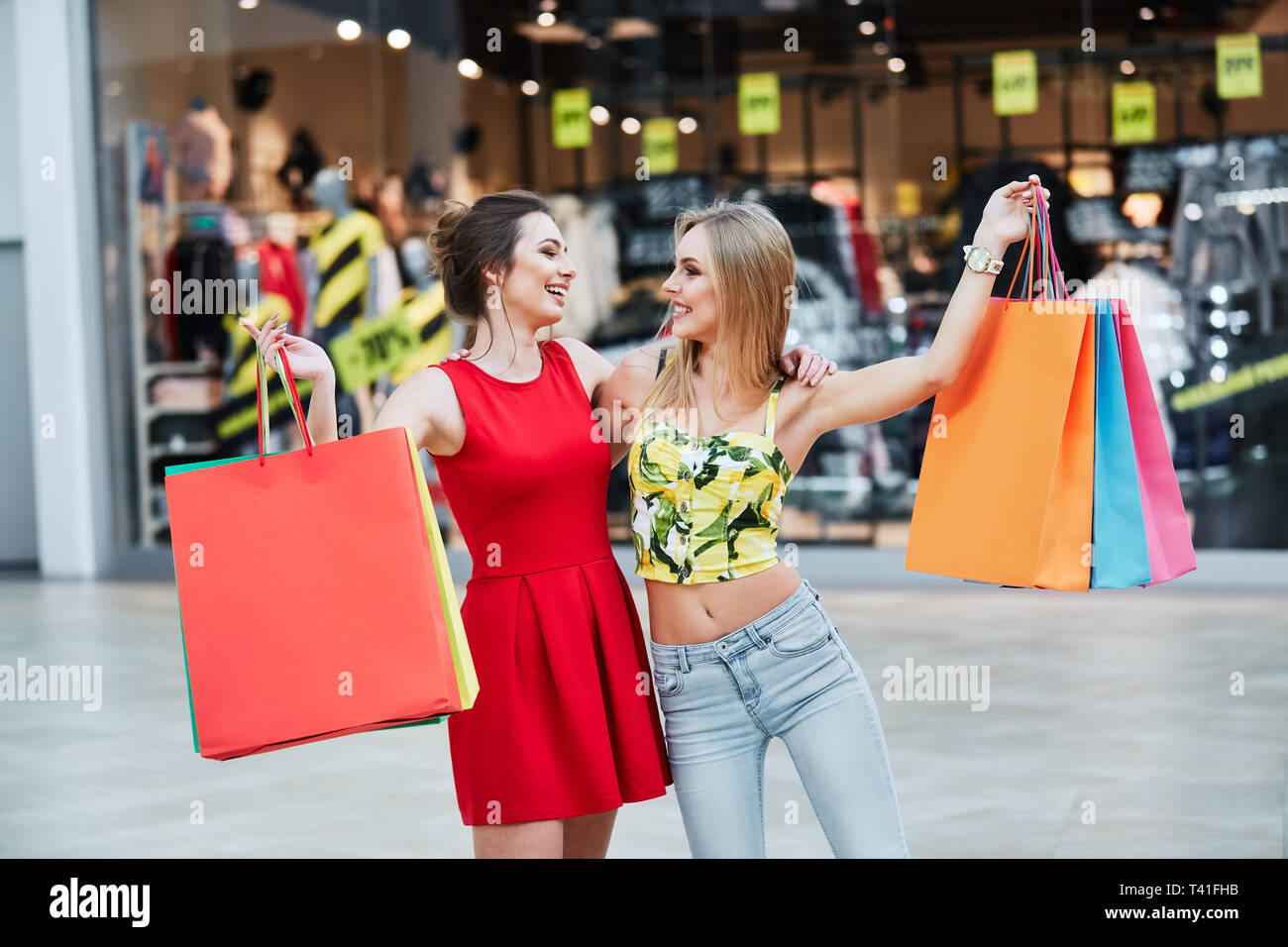Pretty girls posing while shopping Stock Photo - Alamy