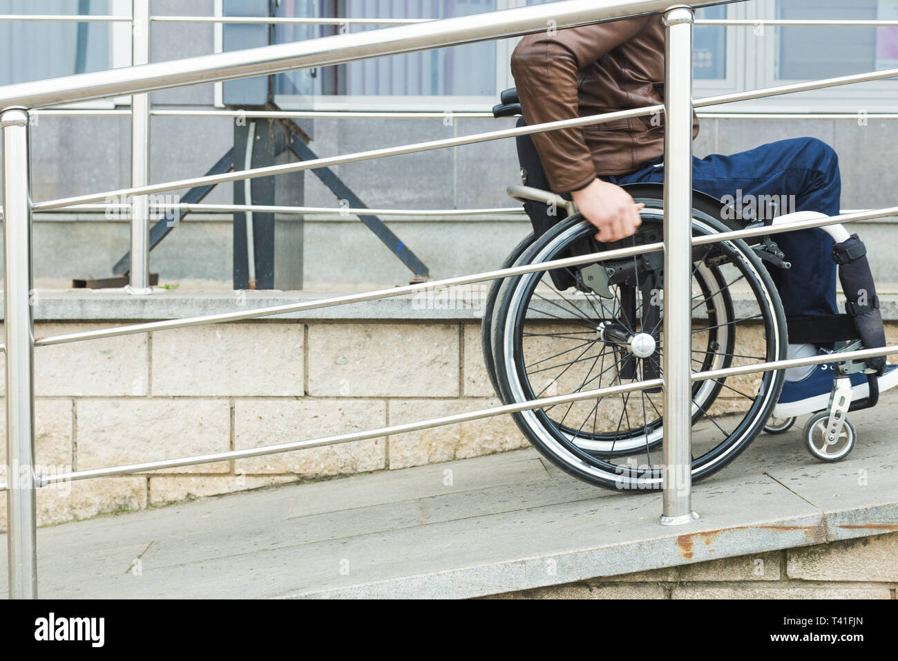 Man in a wheelchair use a wheelchair ramp Stock Photo - Alamy