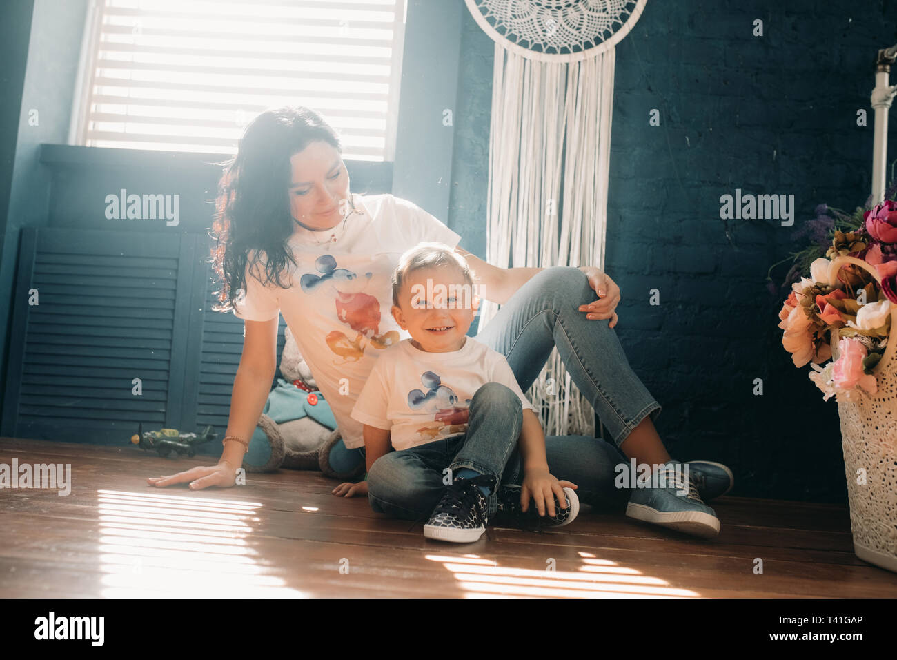 Mother sits with her little son on a floor opposite the window Stock ...