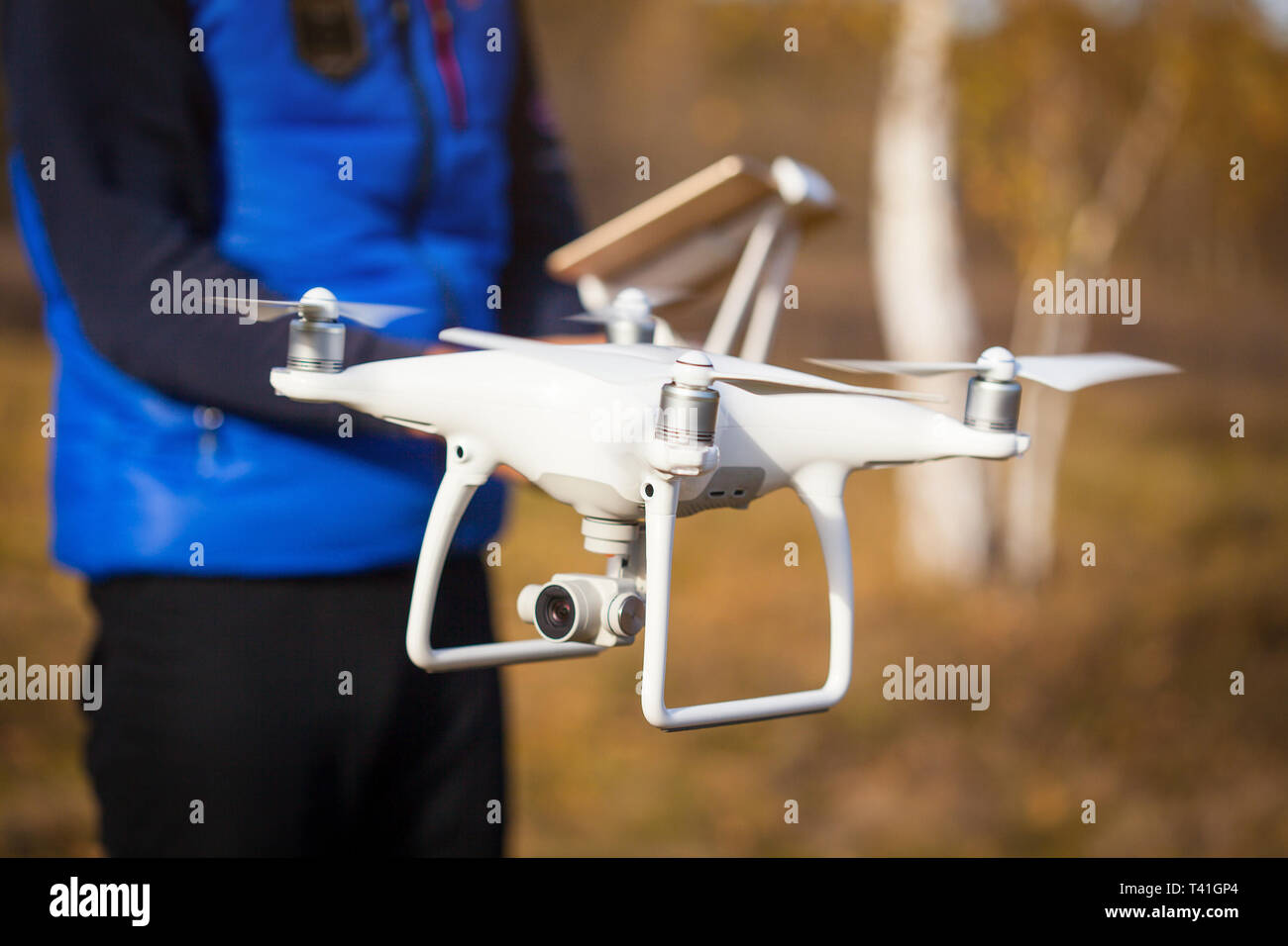 Man operating drone flying by remote control in the park Stock Photo ...
