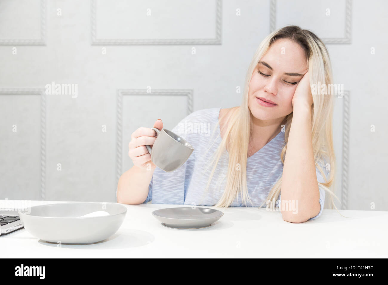 Young pretty woman falls asleep at breakfast in the kitchen Stock Photo ...
