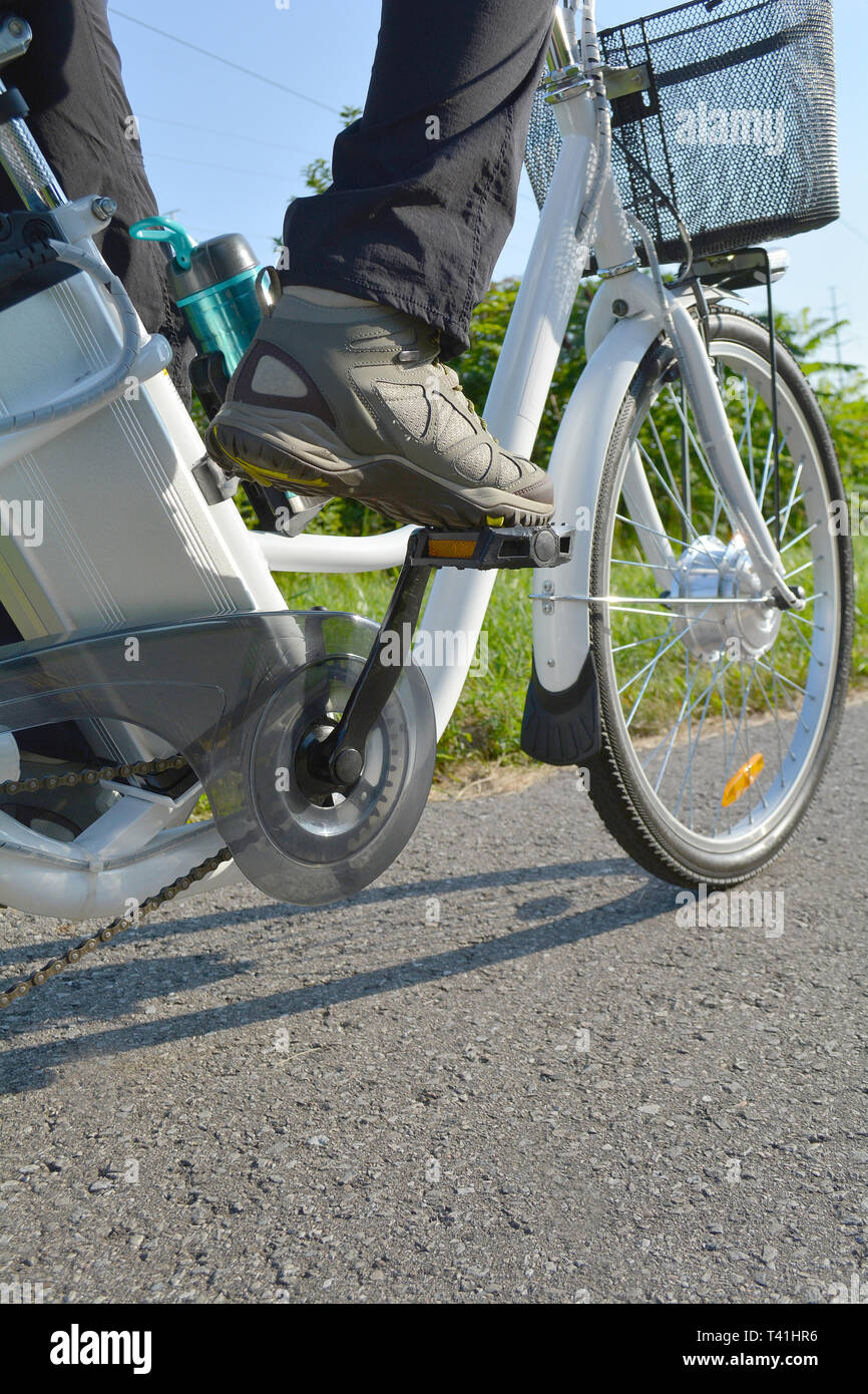 Riding e-bike or electric bicycle, shot from below, ecology concept. E ...